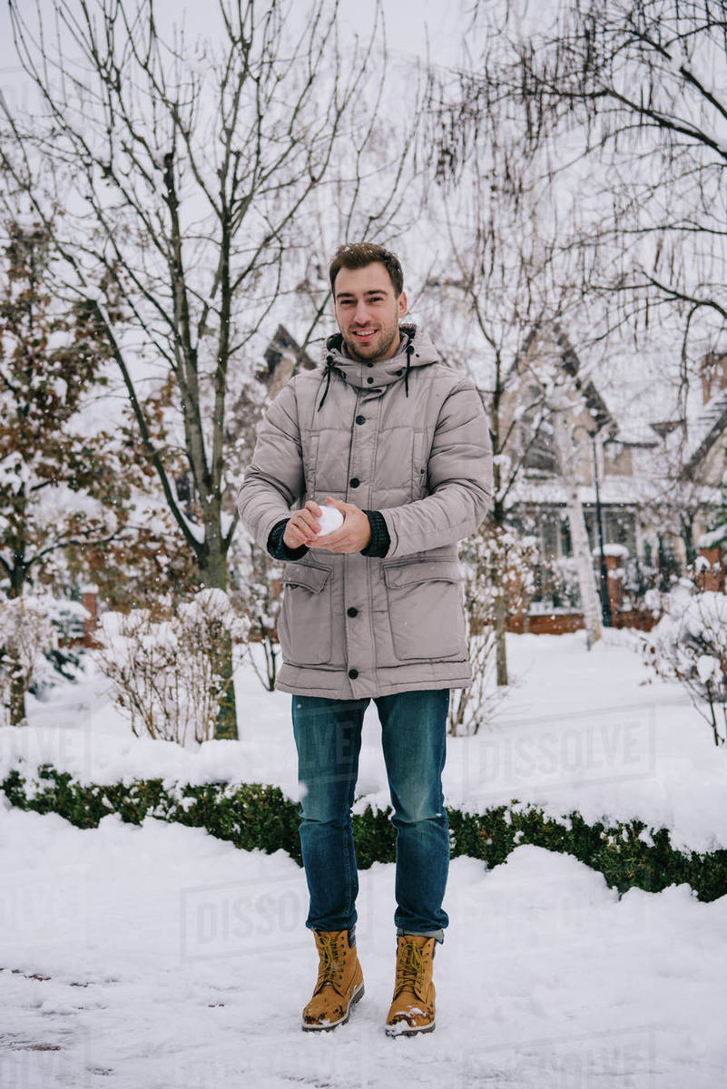 Cheerful man holding snowball in hands in winter - Royalty-free Stock ...