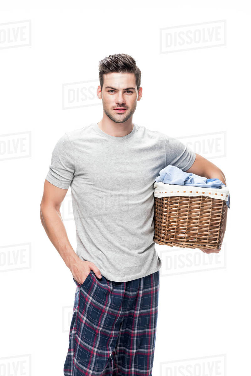 Handsome man with basket of laundry looking at camera isolated on white ...