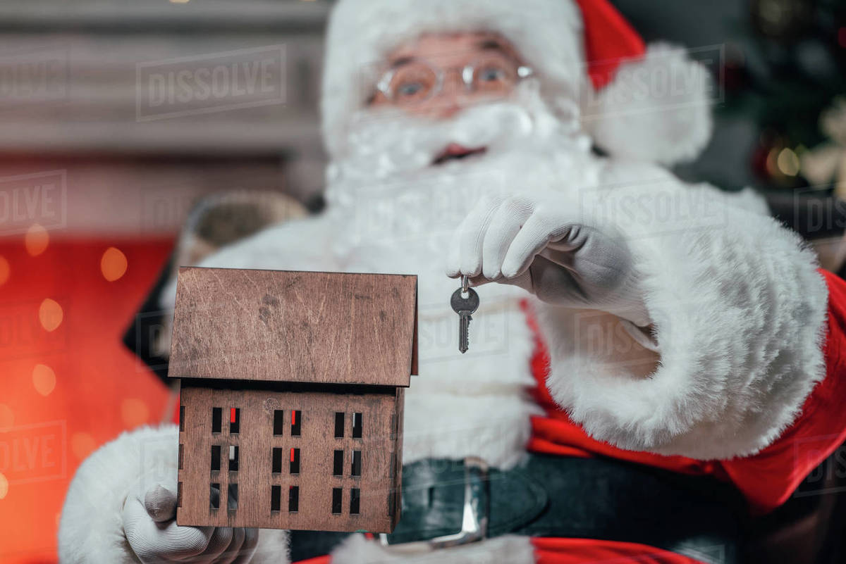 santa claus in traditional red costume holding house model and key ...