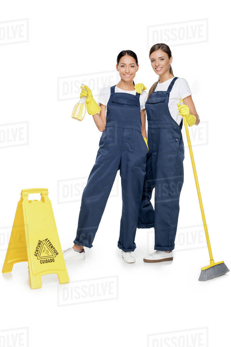 multiethnic smiling cleaners in uniforms with broom and detergent ...