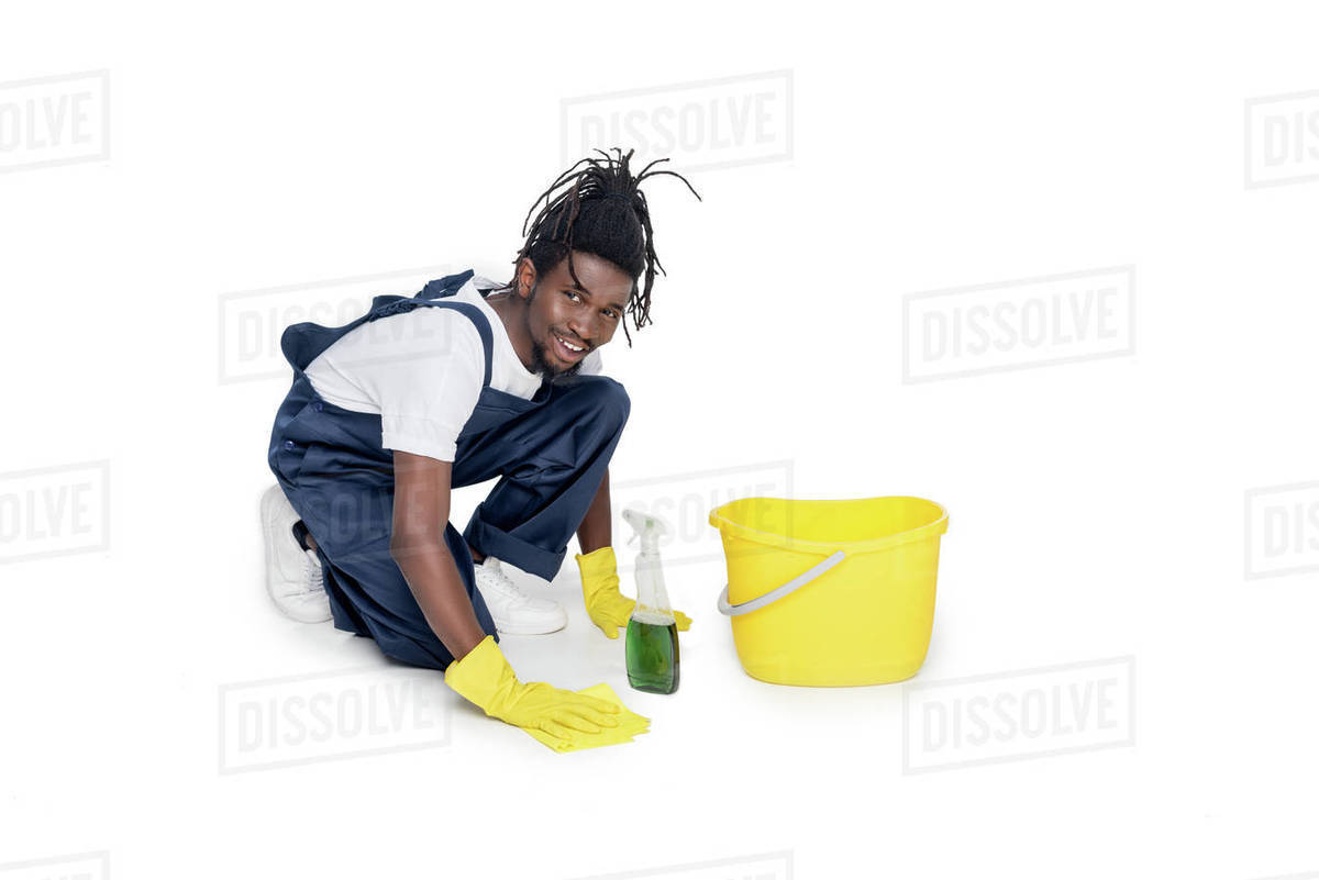 african american cleaner washing floor and smiling at camera - Royalty ...