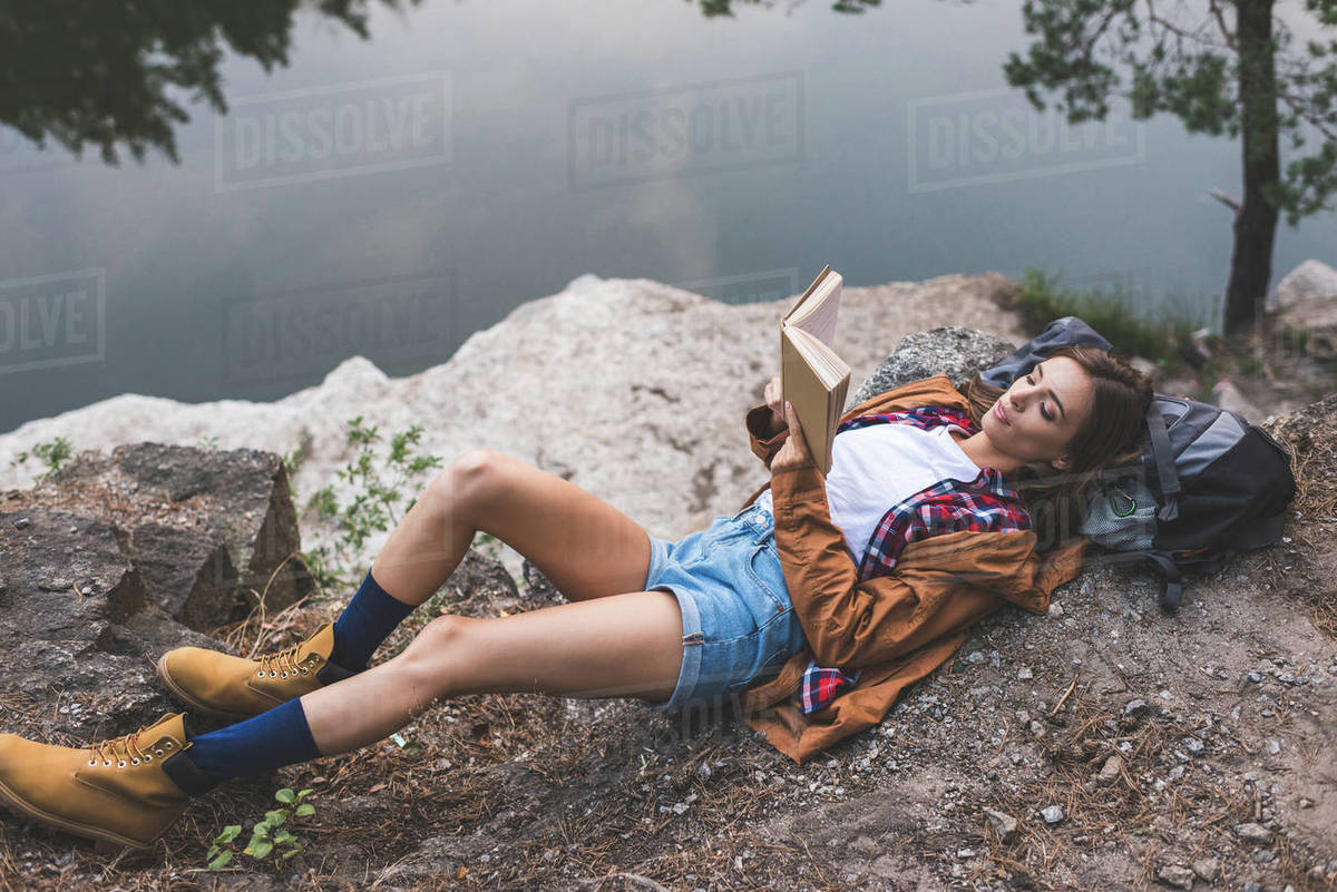 beautiful young woman reading book on nature near lake - Stock Photo ...
