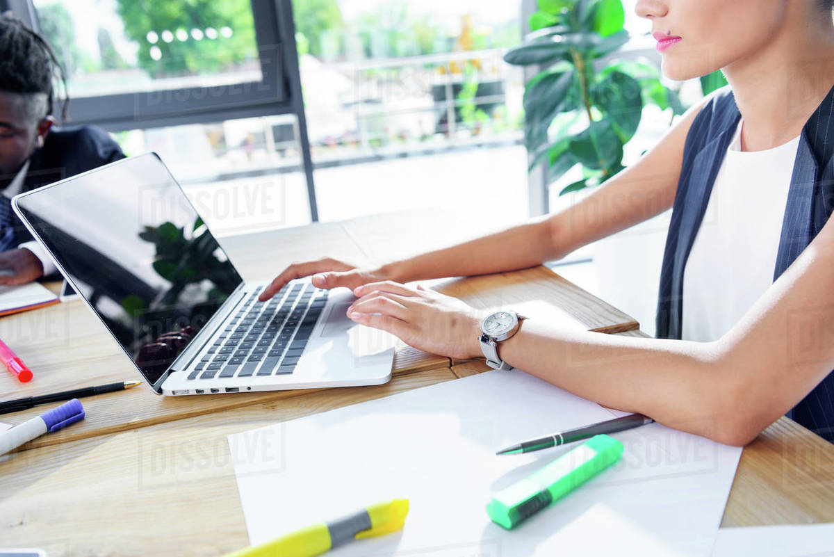 cropped shot of young businesswoman using laptop with blank screen at ...