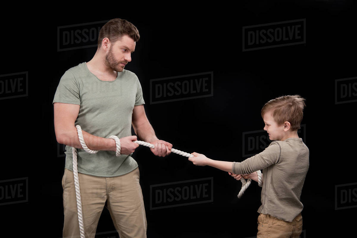 Father and son pulling rope isolated on black, family problems concept ...