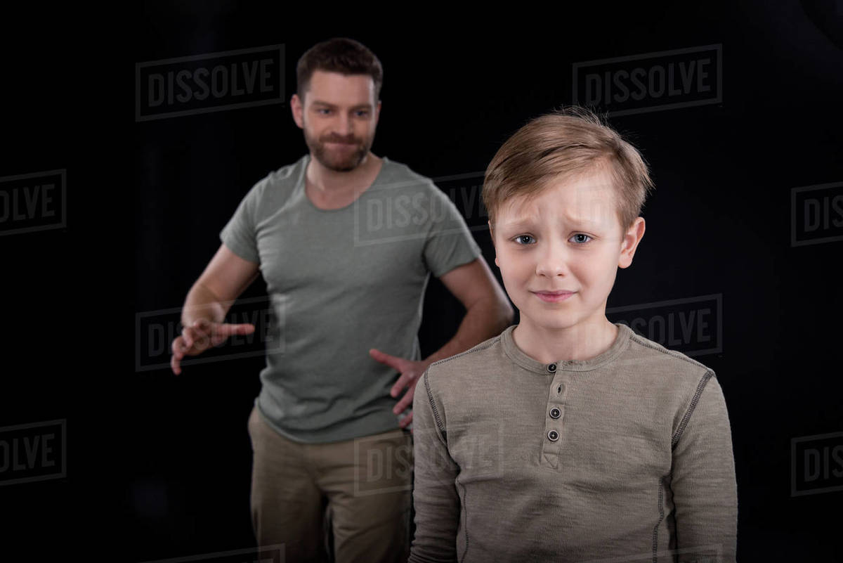 Angry father gesturing and looking at scared son, family problems ...
