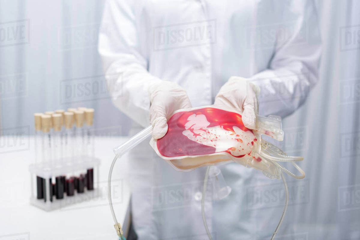 Cropped shot of doctor in lab coat holding medical equipment for blood ...