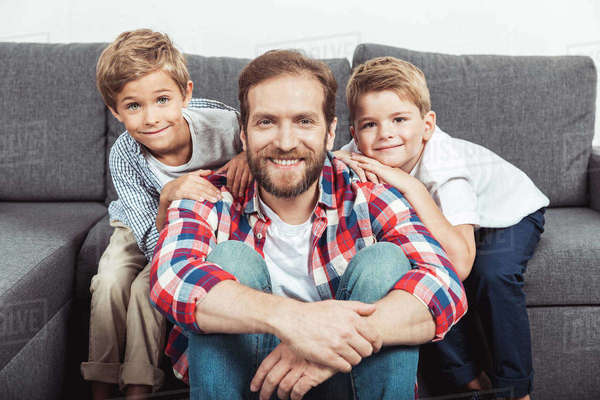 Portrait of happy father with sons smiling at camera - Royalty-free ...