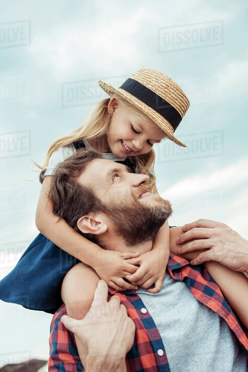 Little girl hugging happy father while piggybacking together - Royalty ...