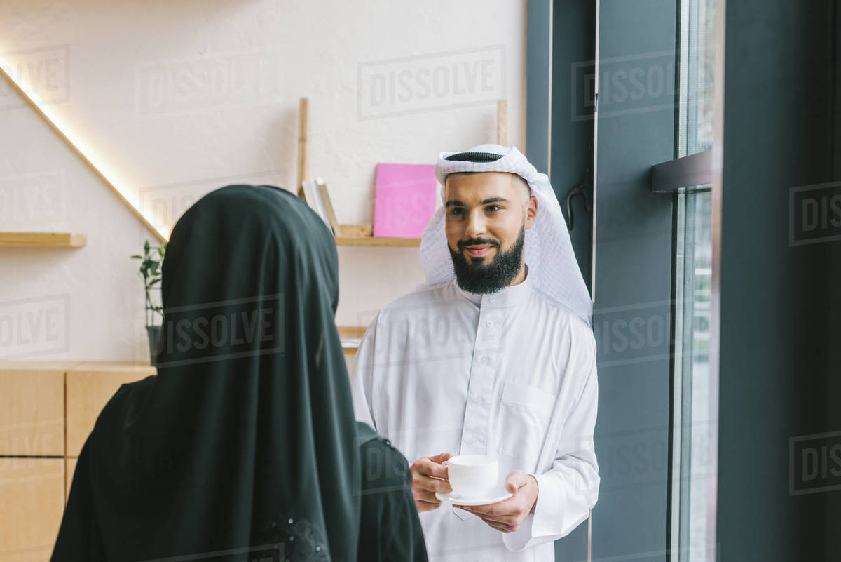 muslim man drinking coffee and talking with woman - Royalty-free Stock ...