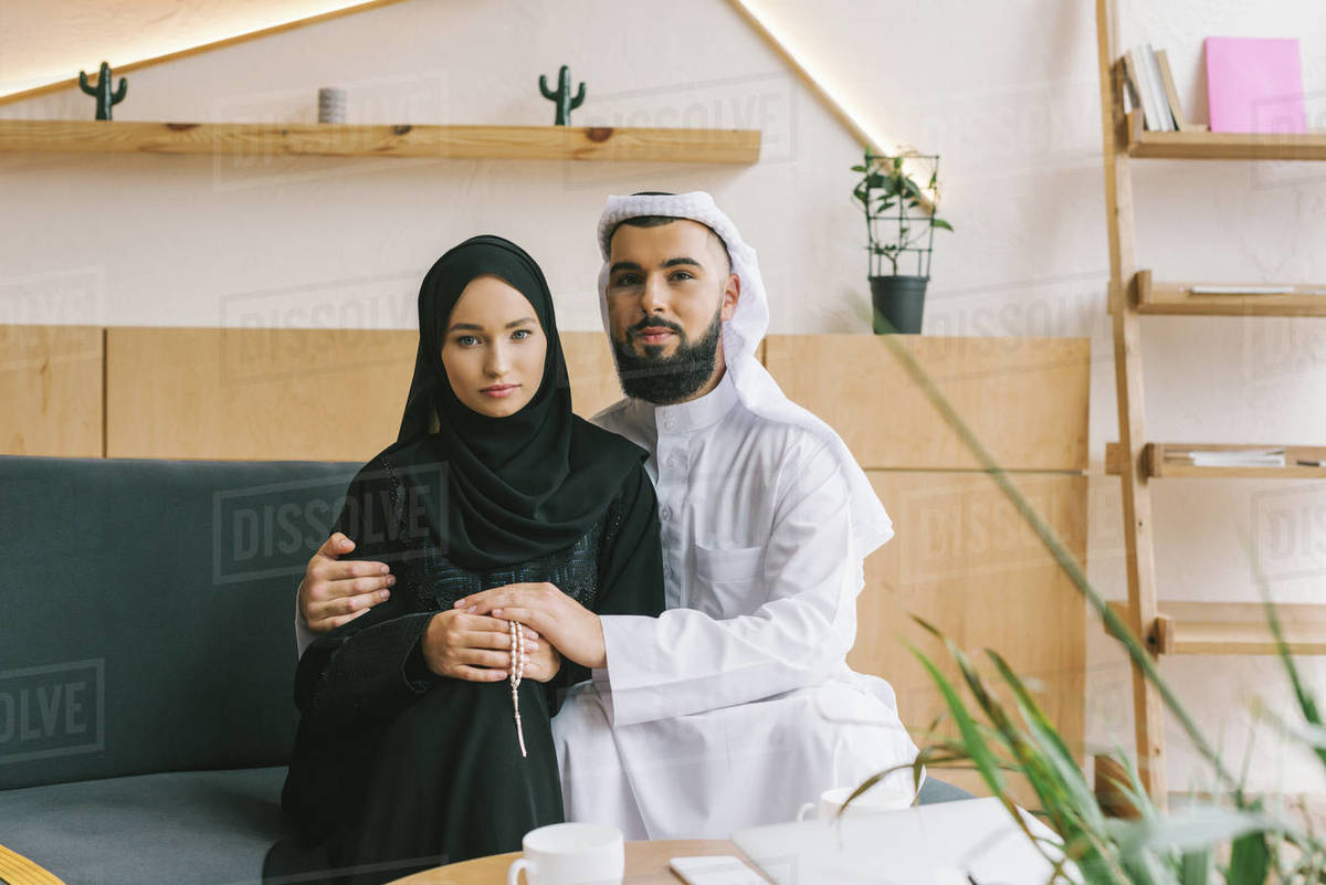 muslim couple sitting on couch and embracing - Royalty-free Stock Photo ...