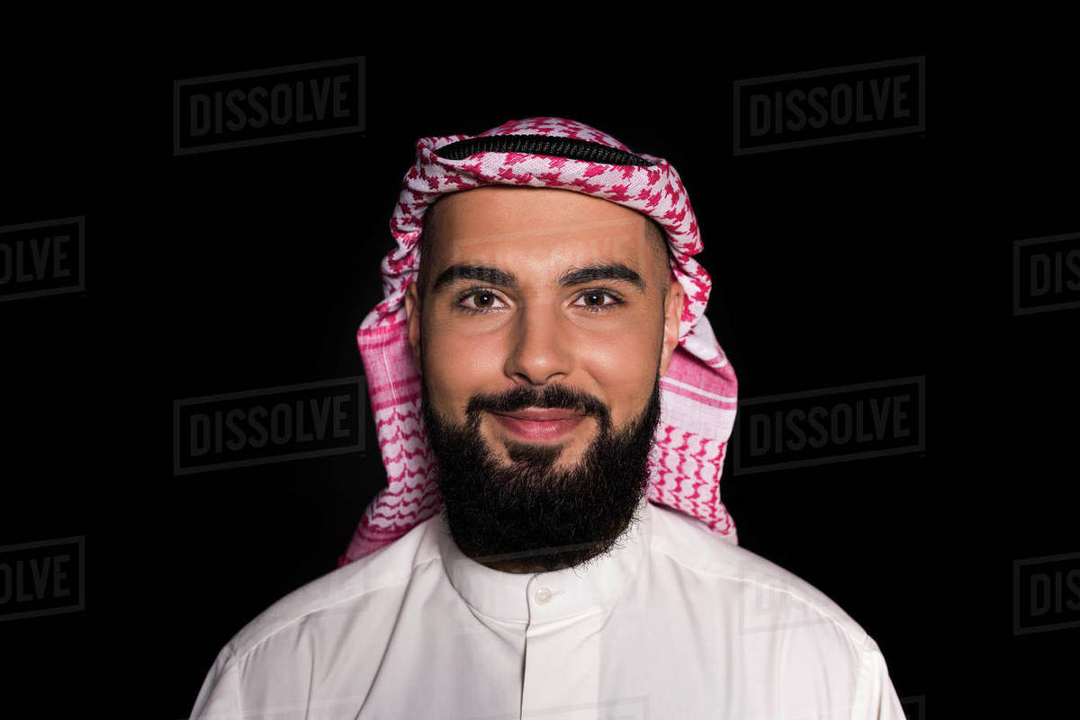 smiling muslim man looking at camera isolated on black - Royalty-free ...