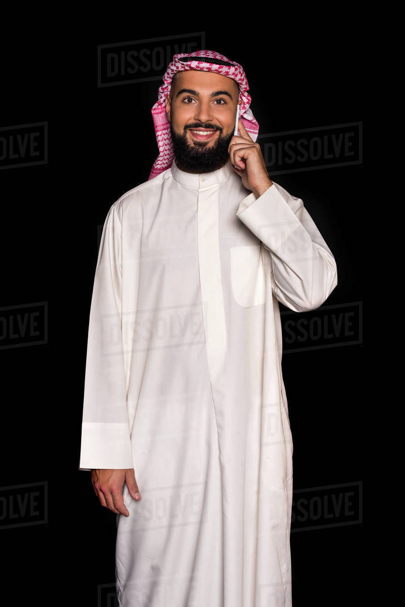 smiling muslim man talking by phone isolated on black - Stock Photo ...