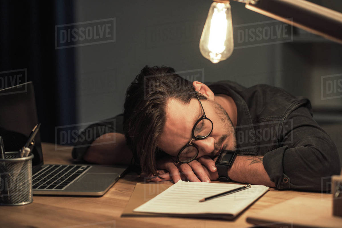 Overworked young musician sleeping at workplace with blank music ...