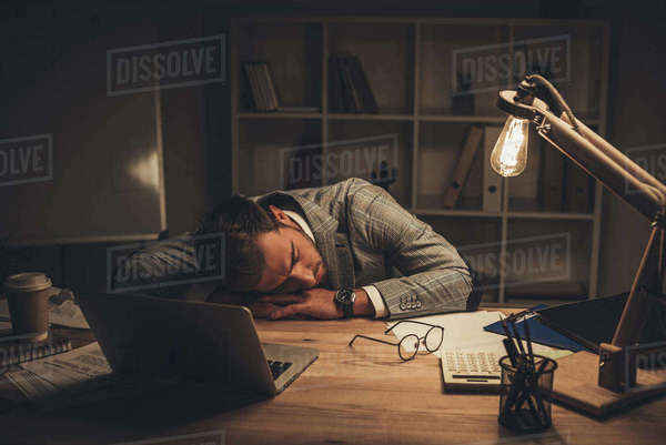 Sleeping overworked businessman in office at night - Royalty-free Stock ...