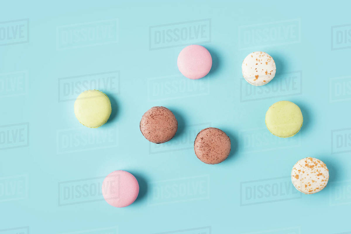 Flat lay with arranged various sweet macarons isolated on blue ...