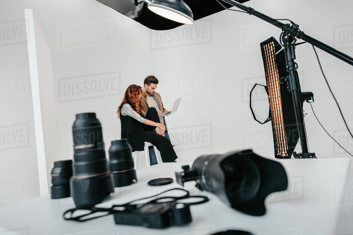 professional photographer and model with laptop in photo studio with ...