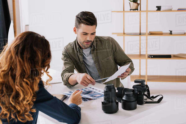 male photographer and model choosing photos for portfolio in modern ...