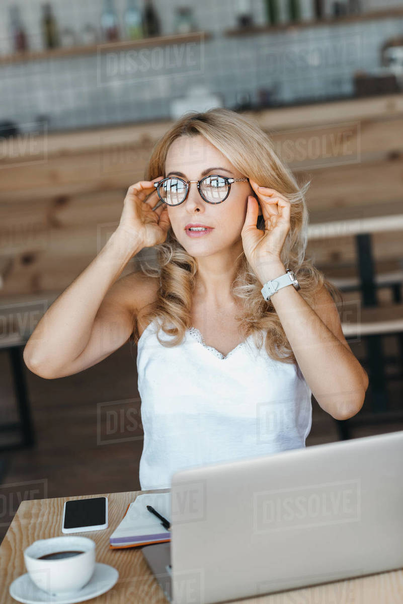 beautiful blonde businesswoman wearing eyeglasses while working with ...