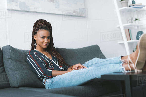 African American woman relaxing on couch at home - Royalty-free Stock ...
