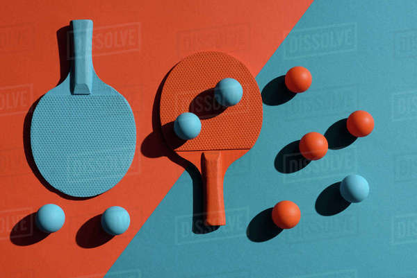 Top view shot of ping pong rackets and balls placed on two toned ...