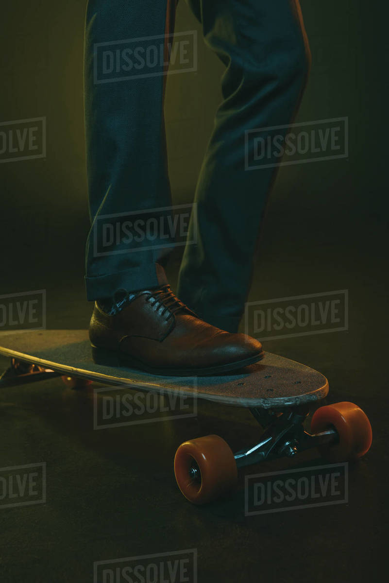 Cropped shot of man in formal wear riding on skateboard - Royalty-free ...