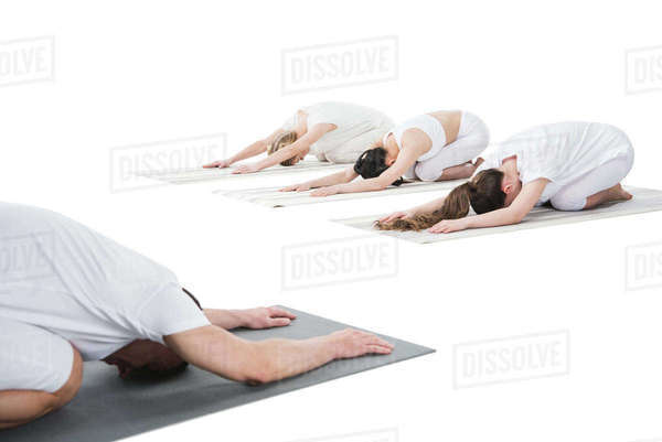 Women practicing mudrasana pose on yoga mats with trainer isolated on ...