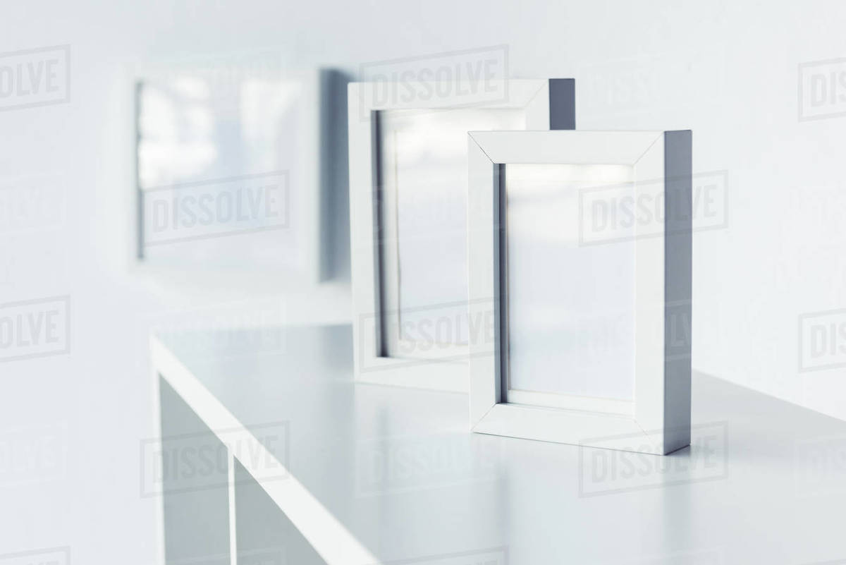 Close up view of empty photo frames standing on bookshelf - Royalty ...