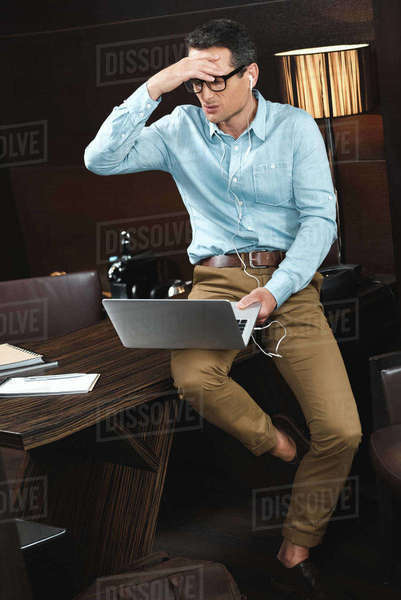 Businessman in business casual clothing sitting on table and watching ...