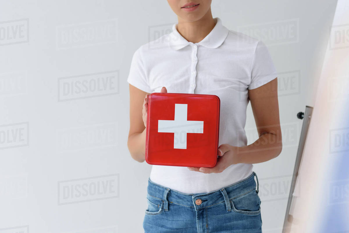 Cropped view of woman presenting red first aid kit, isolated on white ...