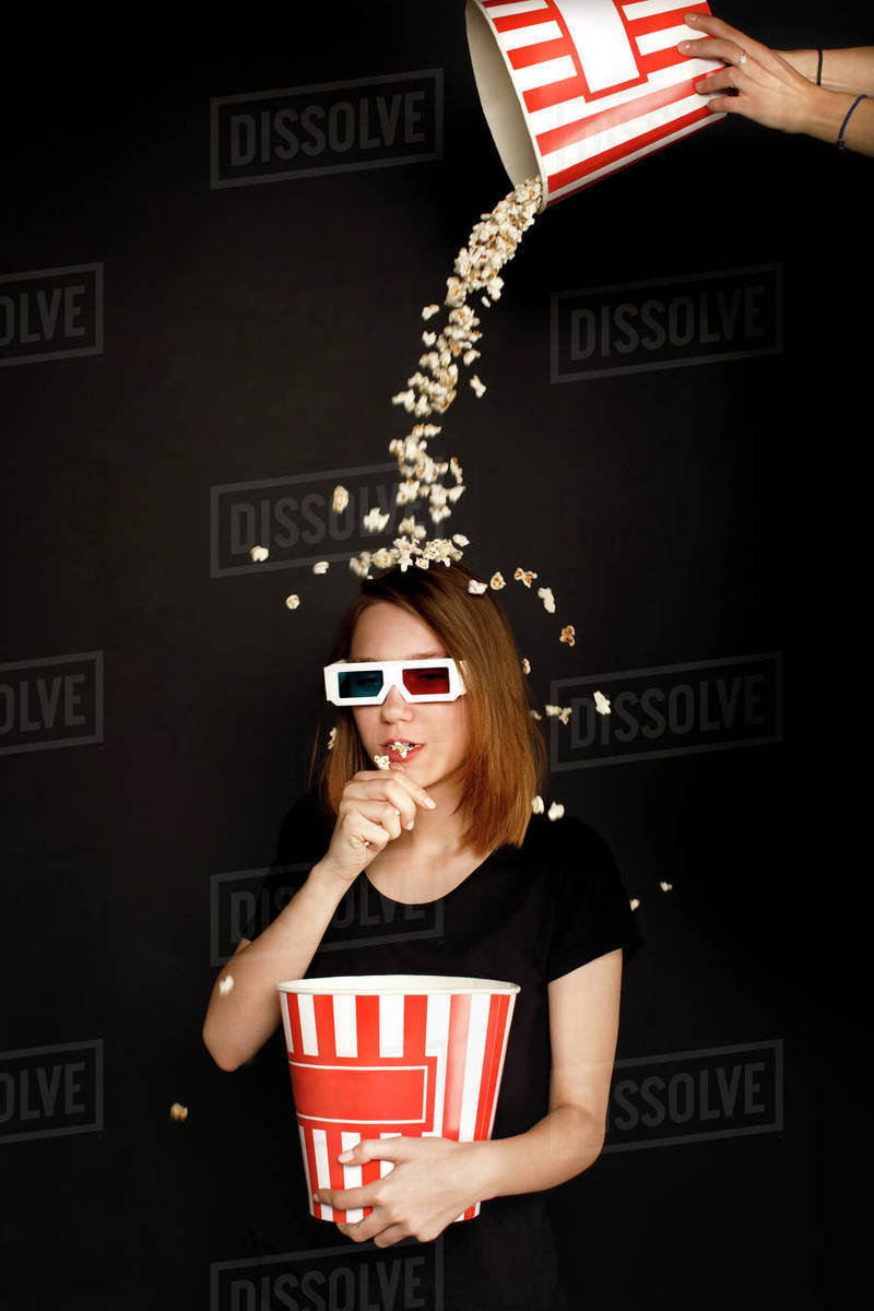 Woman with popcorn spilling on her head isolated on black - Royalty ...