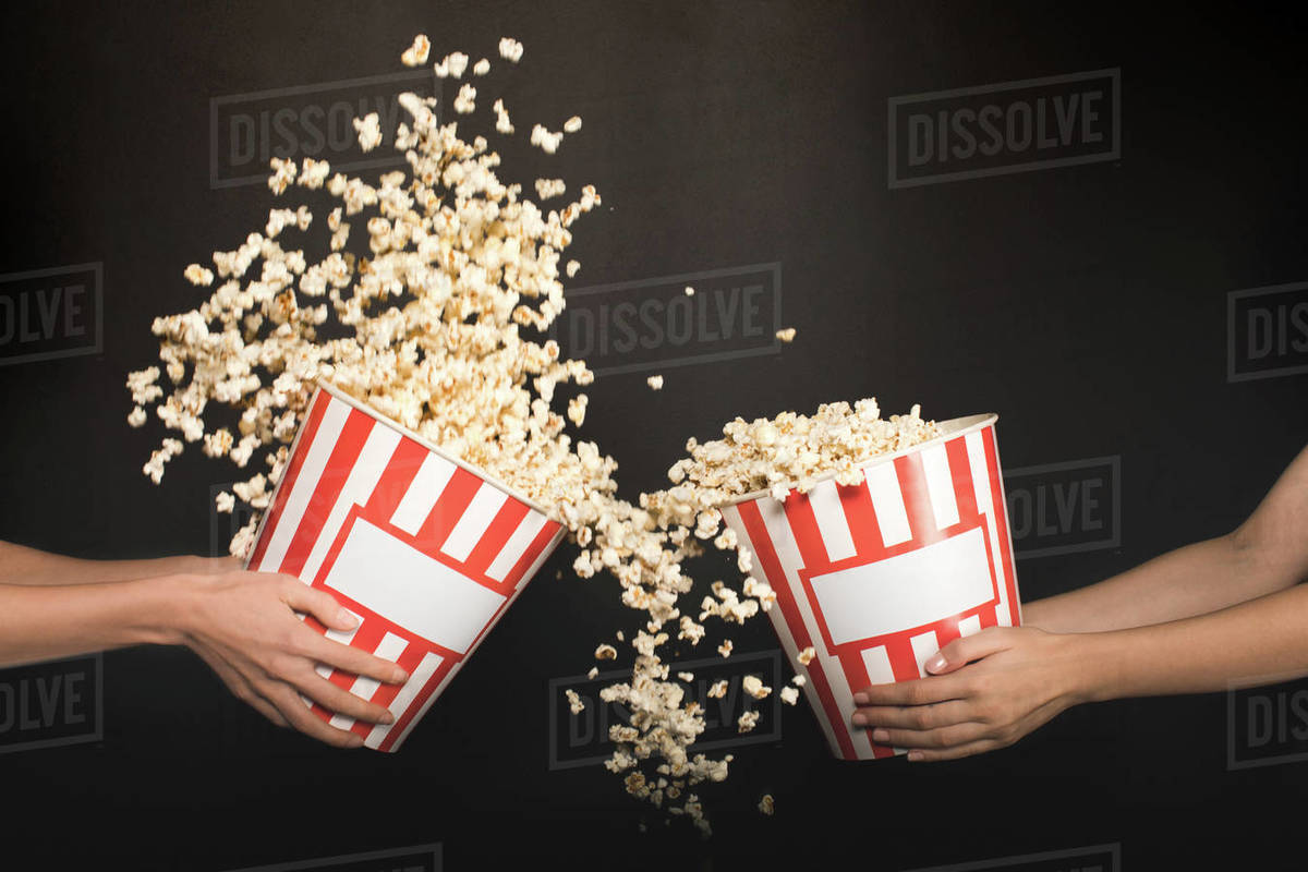 Cropped shot of people spilling out popcorn from buckets isolated on ...