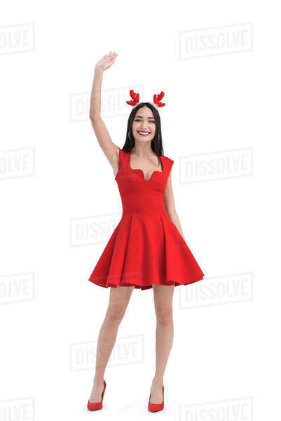 Cheerful Asian woman in deer costume waving to someone isolated on ...
