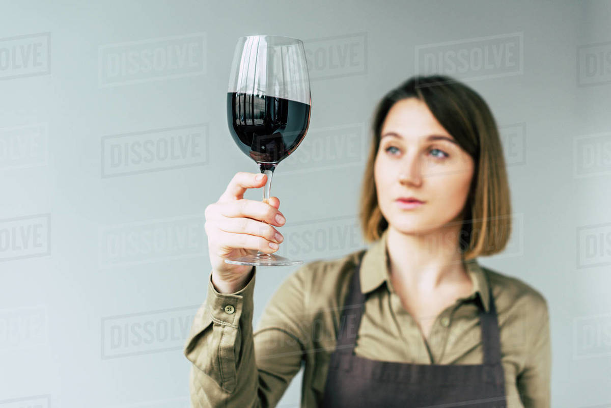Portrait of female sommelier examining red wine - Royalty-free Stock ...