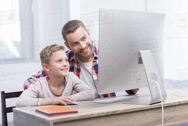 Happy father and son using desktop computer together - Royalty-free ...