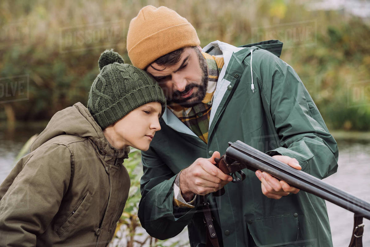 Father showing son how to load gun for hunt - Royalty-free Stock Photo ...