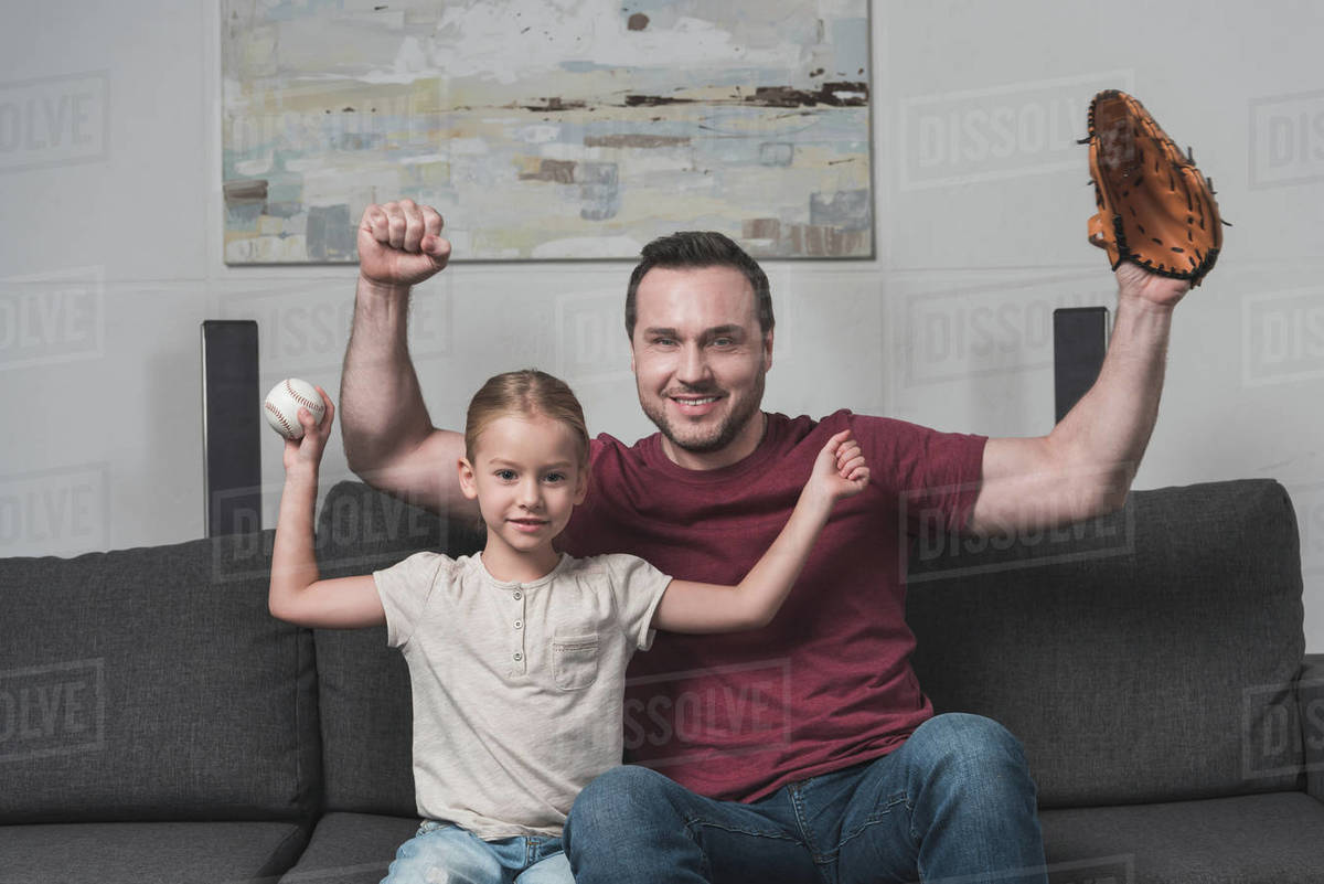 Father and daughter showing muscles holding baseball ball and mitt ...