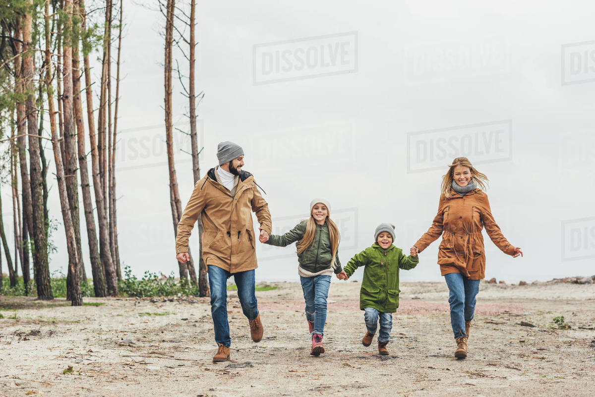 beautiful happy family running together and holding hands on nature ...