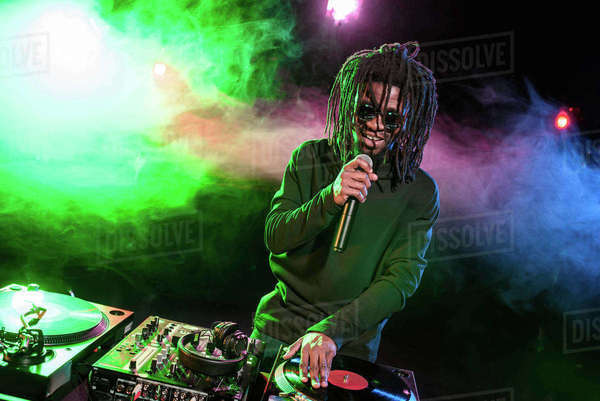 Professional African American club dj in headphones with mixer in ...