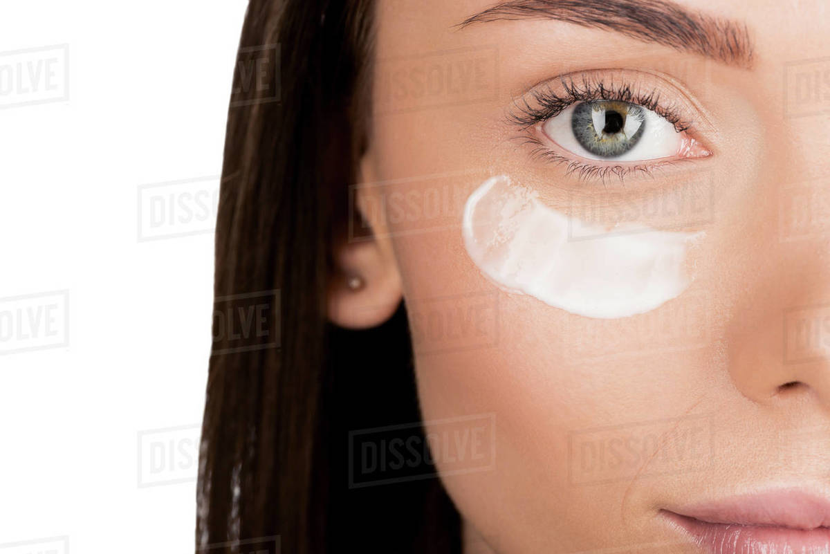 Close-up portrait of young woman with moisturizing cream on face ...