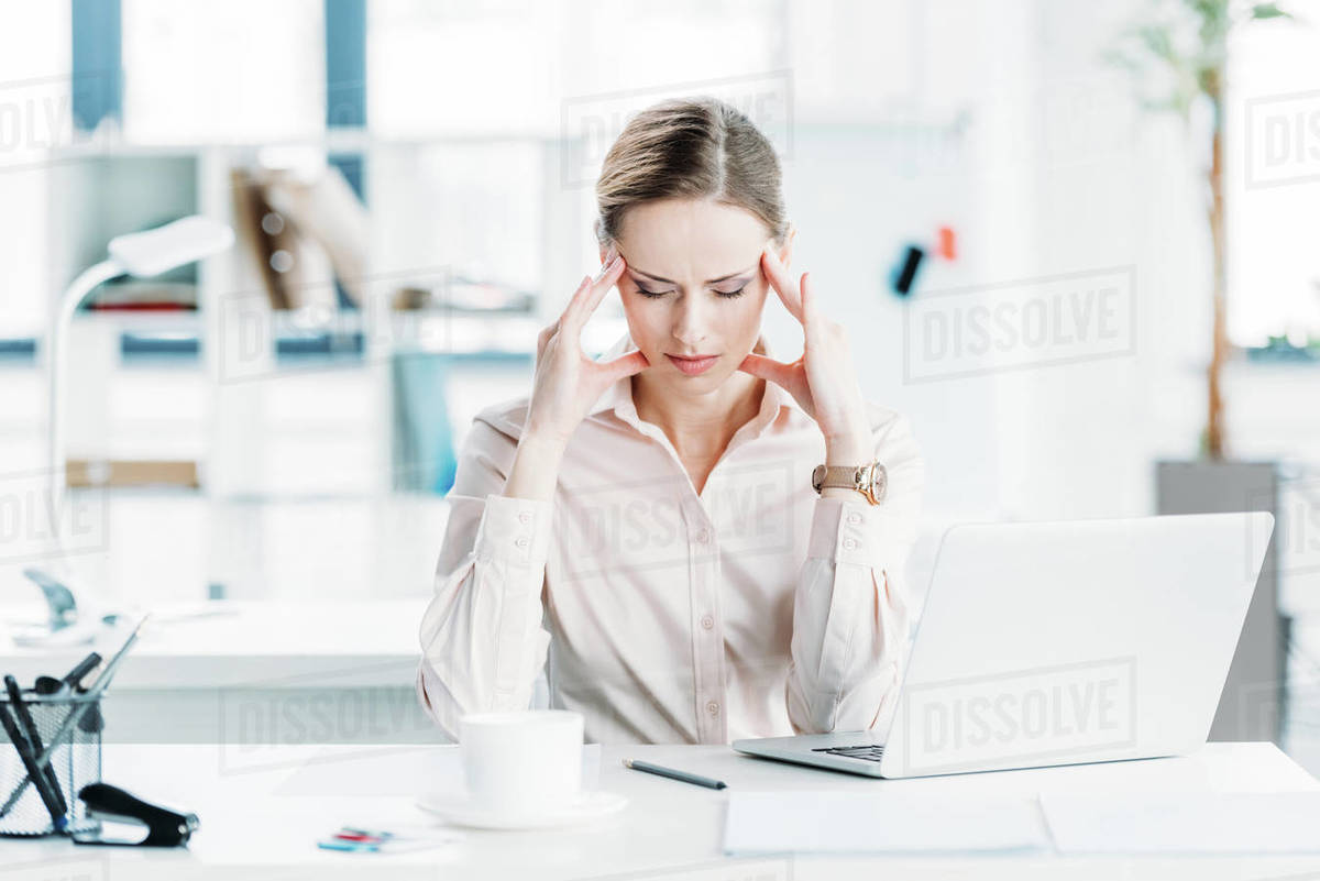 Portrait of stressed businesswoman sitting at workplace in modern ...
