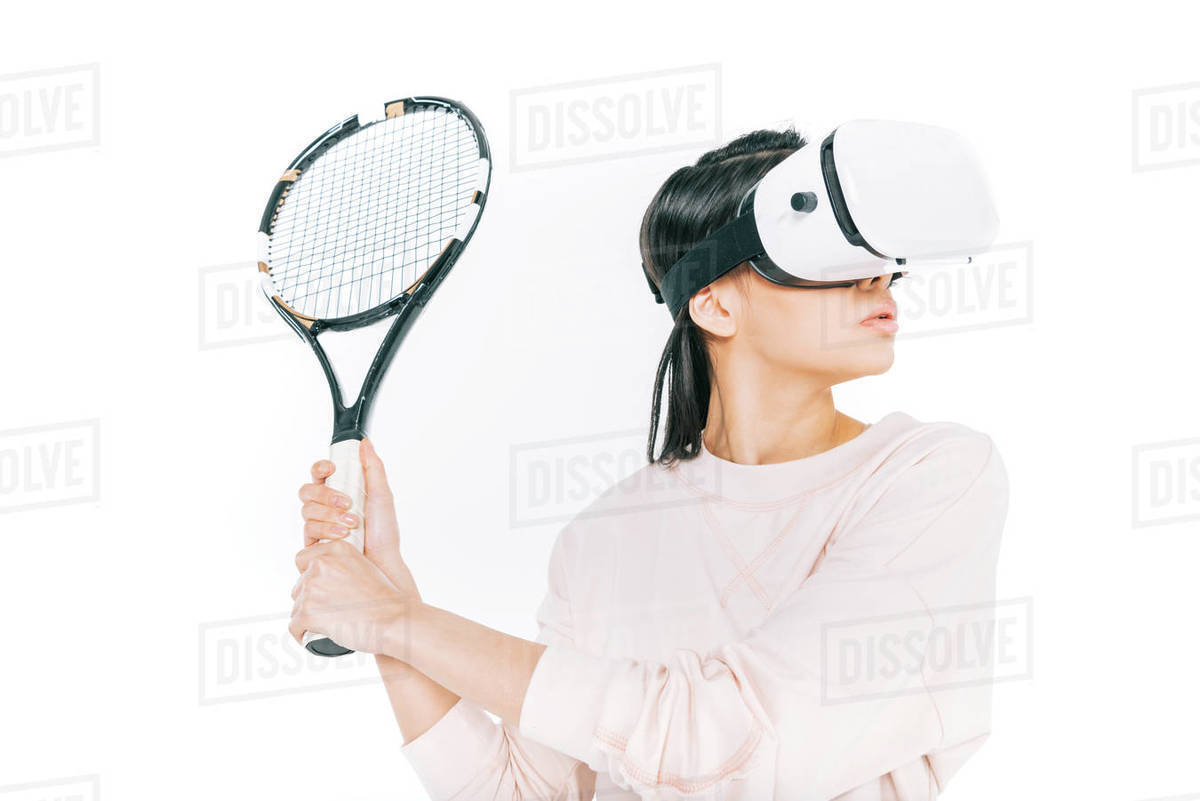 Attractive young Asian woman in virtual reality headset holding tennis ...