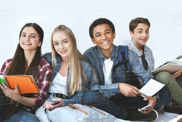 Portrait of multiethnic group of smiling students with notebooks and ...