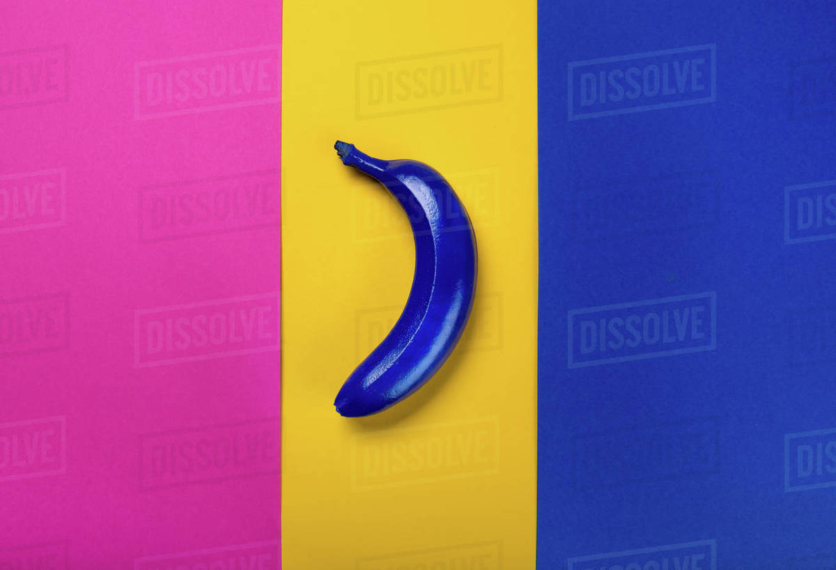 Top view of one whole blue colored banana on colorful background ...