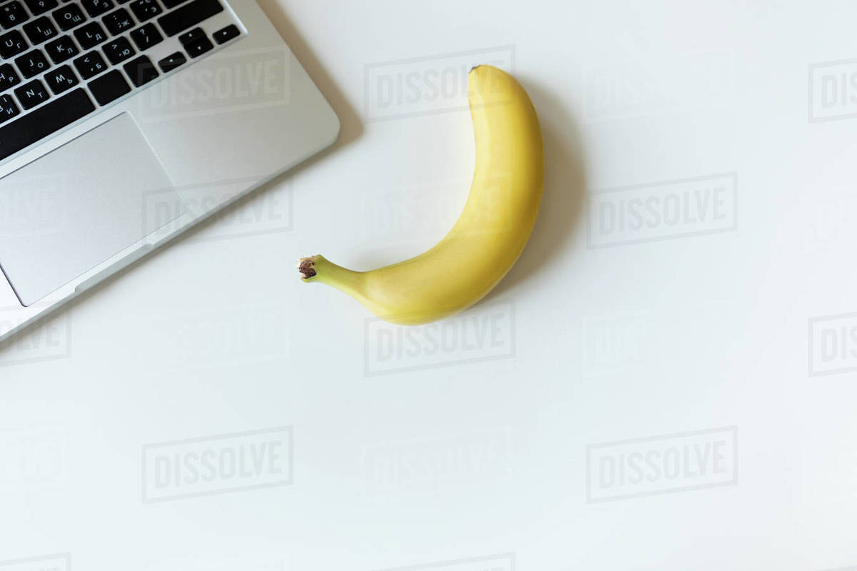 Top view of fresh ripe banana and laptop isolated on grey - Royalty ...
