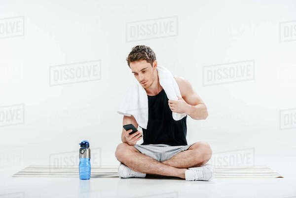 Young man checking activity in smartphone after workout - Royalty-free ...