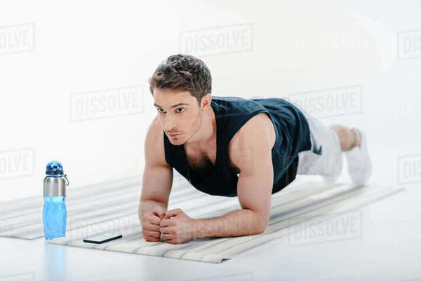 Handsome man standing plank isolated on white - Stock Photo - Dissolve