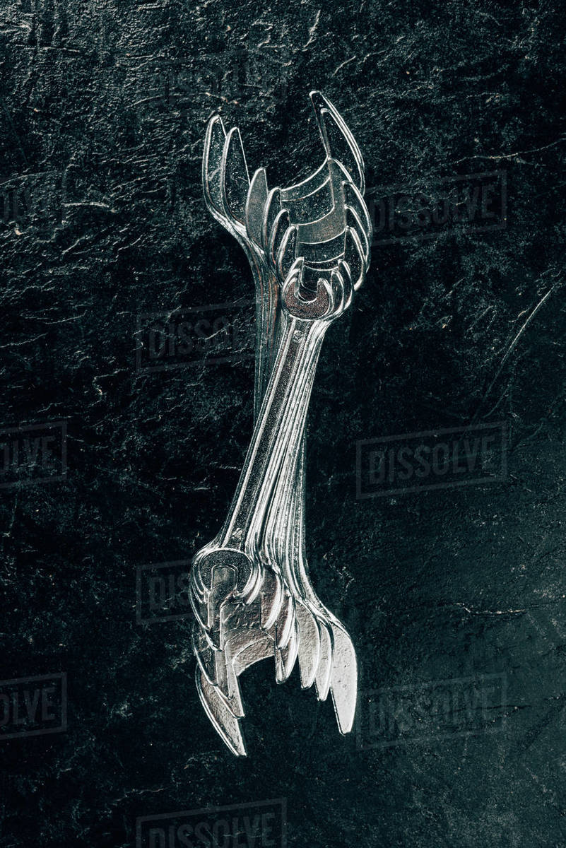 top view of pile of metal wrenches for carpentry on dark tabletop ...