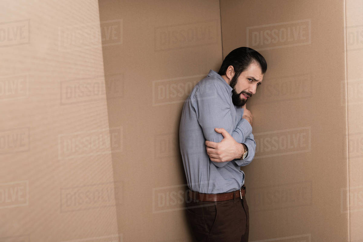 Depressed lonely man hugging himself in cardboard box - Royalty-free ...