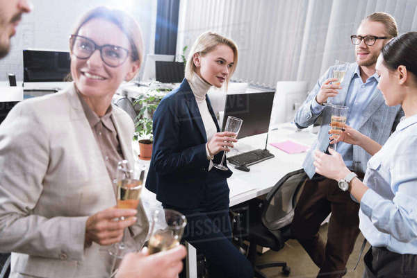 Partial view of young business team drinking champagne together after ...
