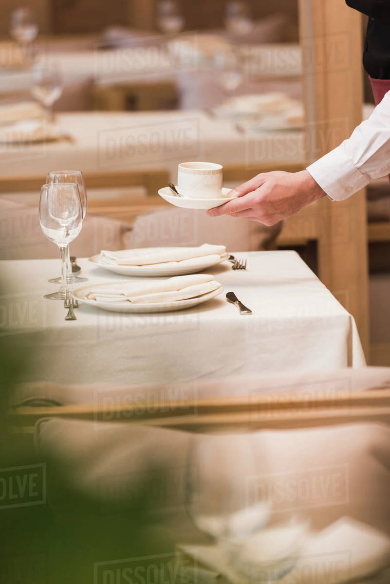 Cropped image of waiter serving cup of coffee on a table - Stock Photo ...